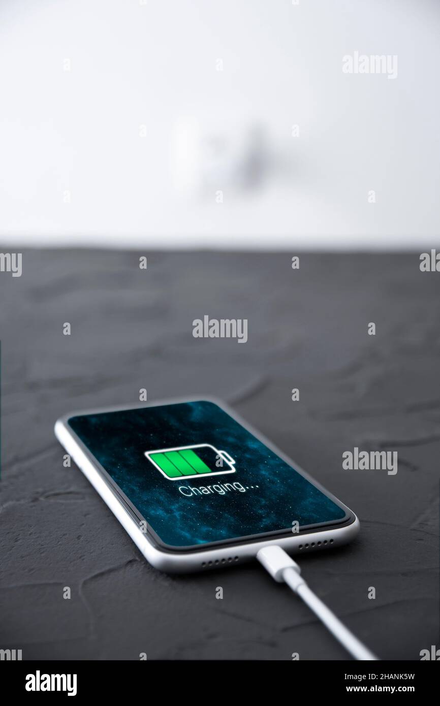 Mobile smart phone on wireless charging device on dark background. Icon ...