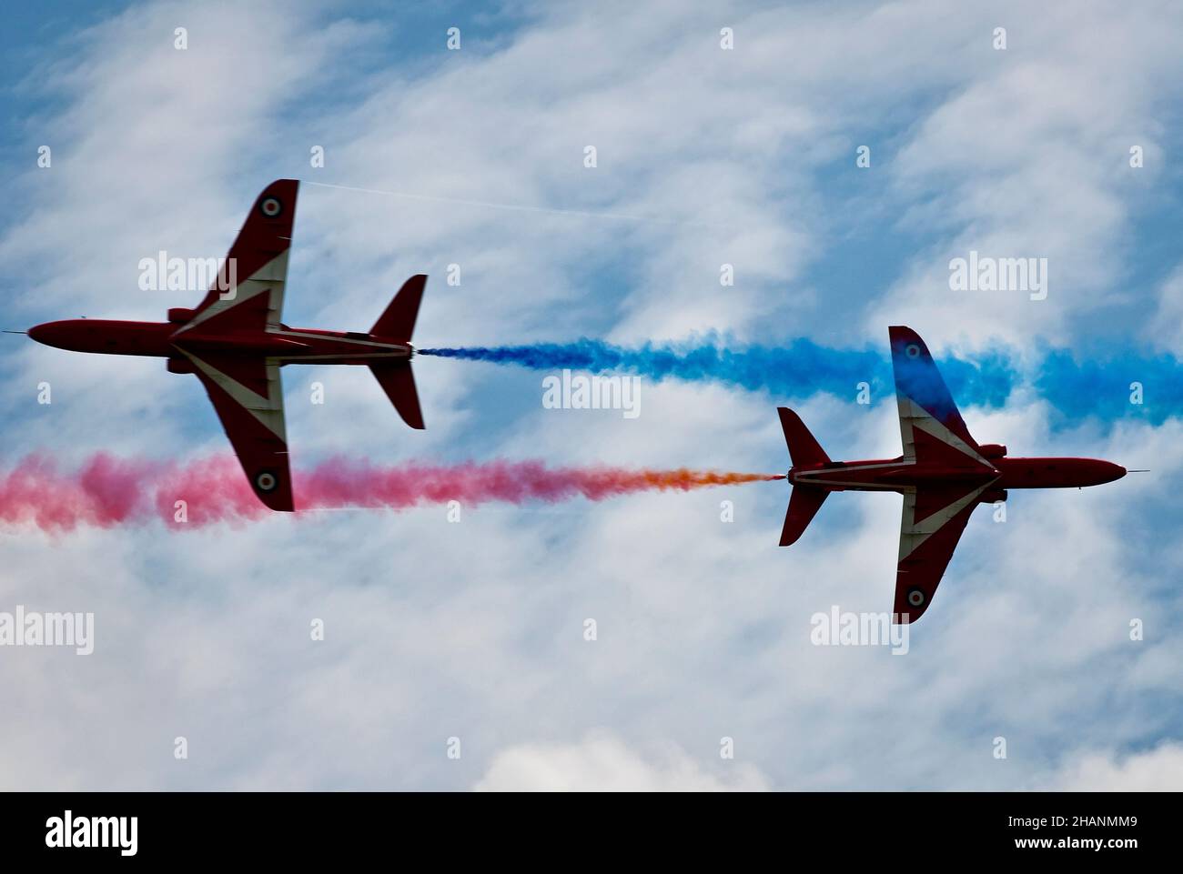 Red arrows crossing at Goodwood UK Stock Photo - Alamy