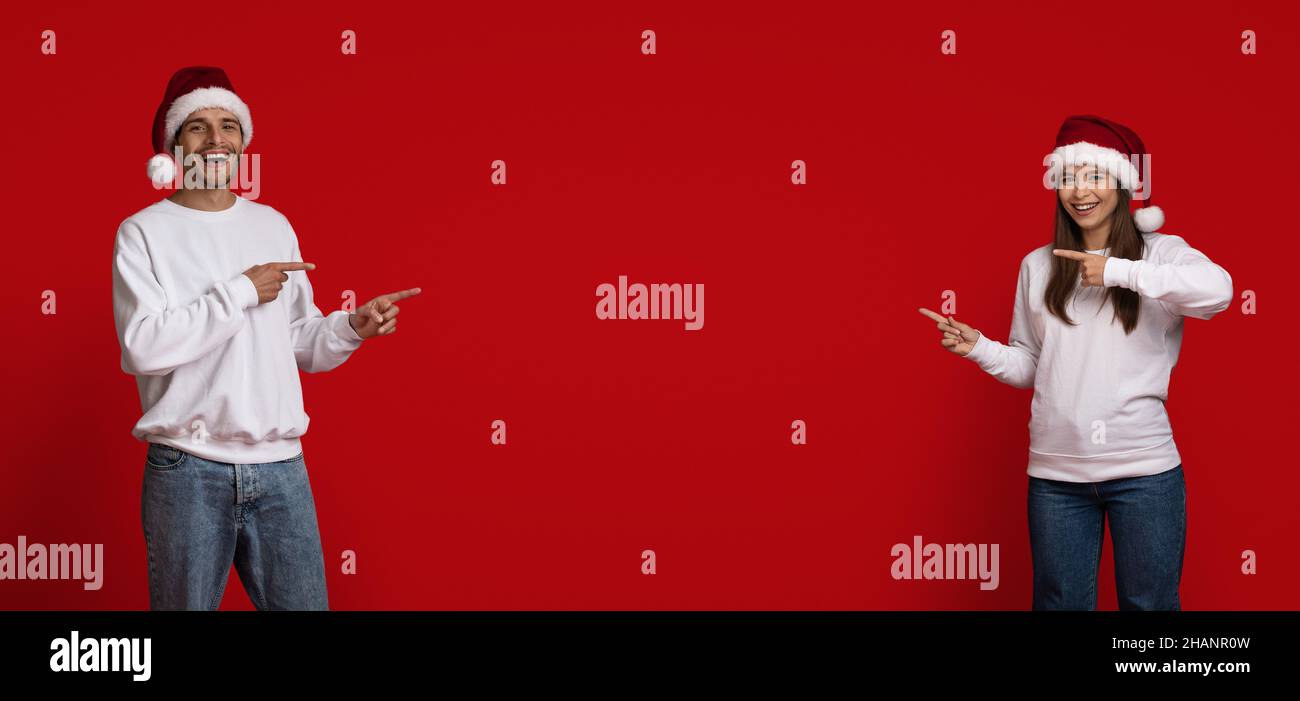 Joyful Couple In Santa Hats Pointing At Copy Space In The Middle Stock ...