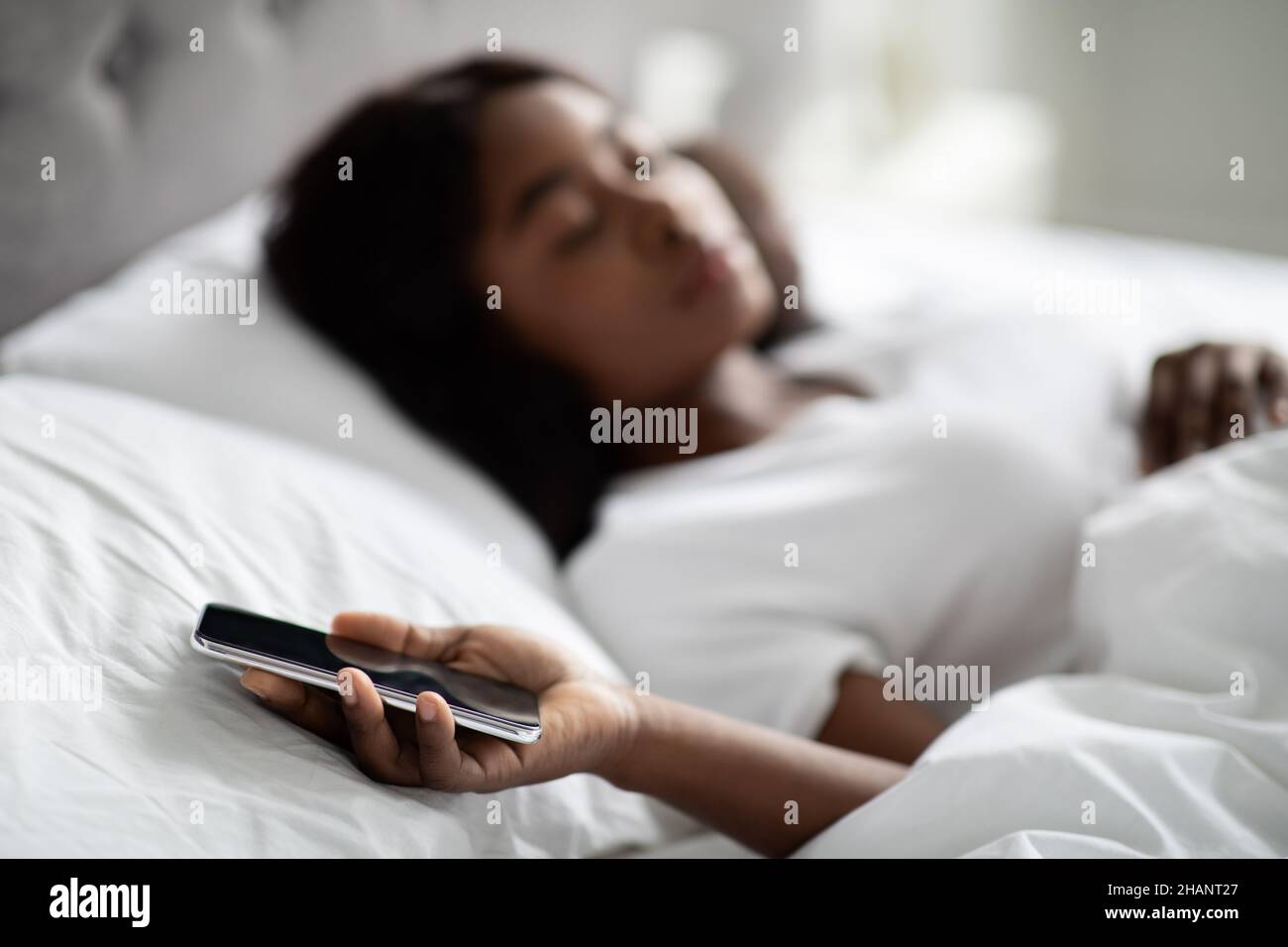 African american lady sleeping with smartphone in her hand Stock Photo ...