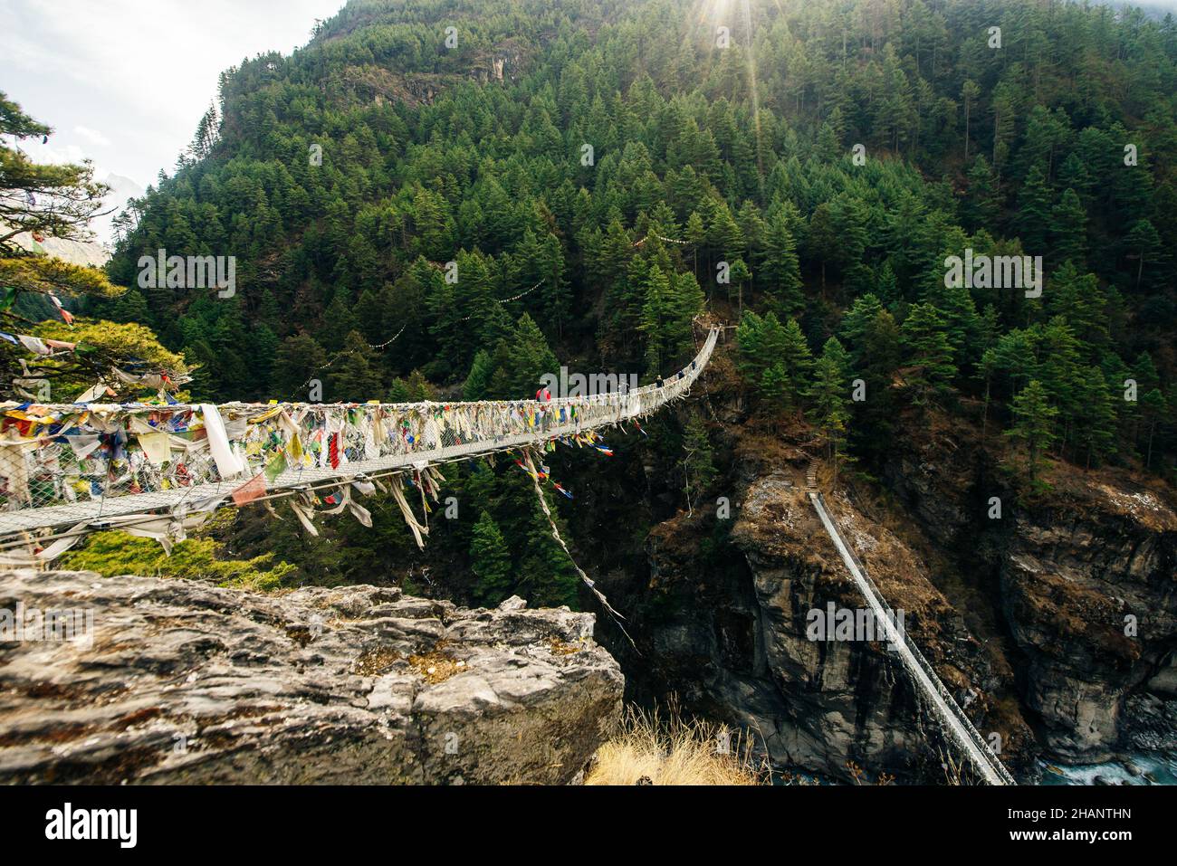 Suspension bridge with buddhist prayer flags on the Annapurna circuit ...