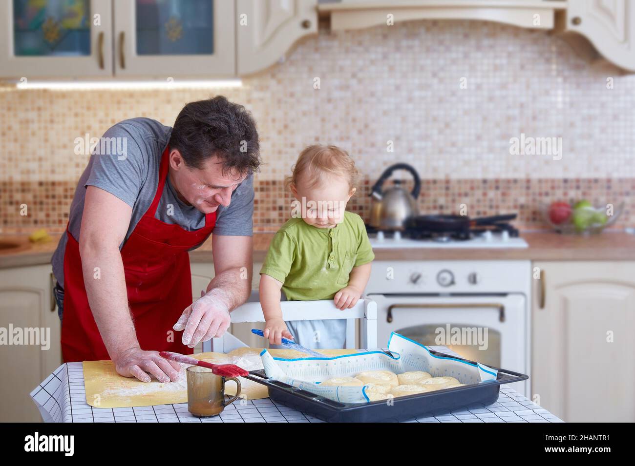 Dad and a small child cook together in the kitchen. The concept of ...