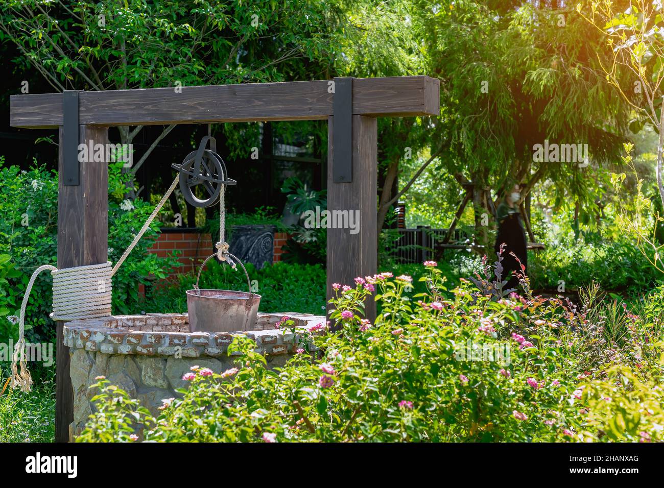 Beautiful artesian well made by stones and wheel pulley with metal ...