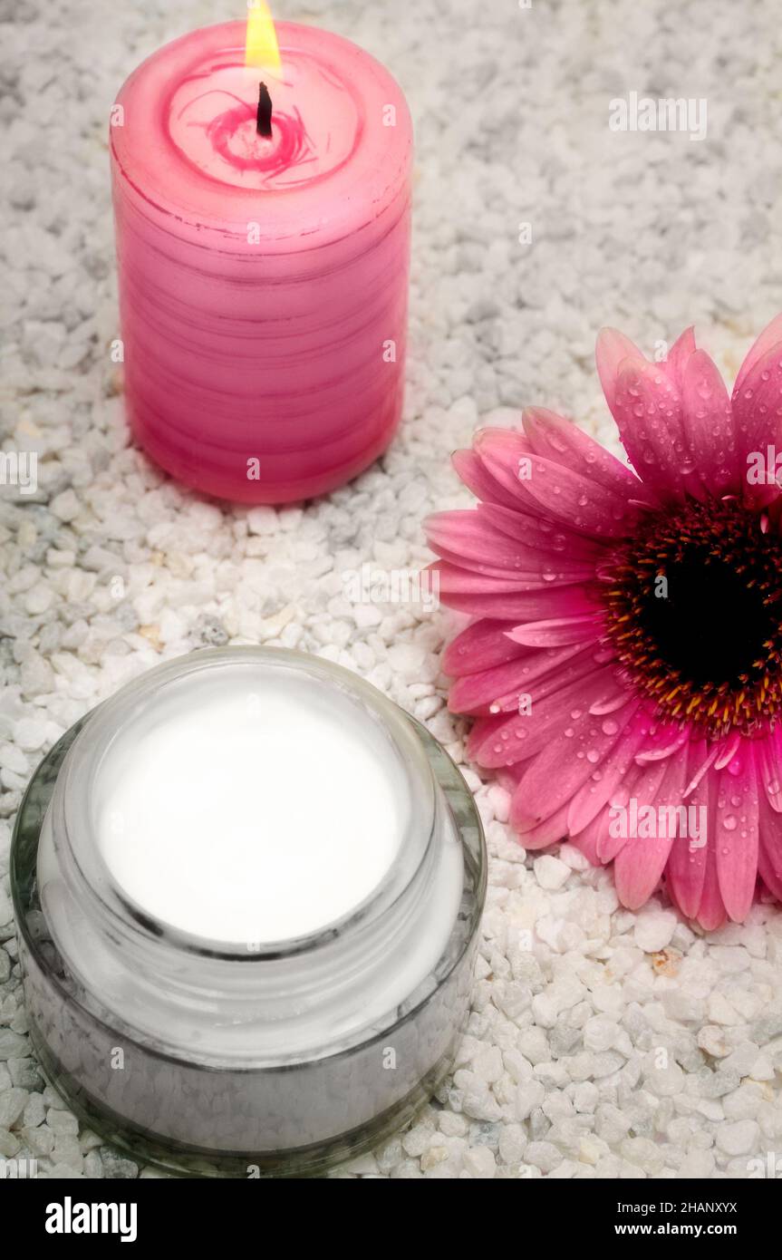 cosmetic cream in a jar, with candle and flower on white stones Stock ...