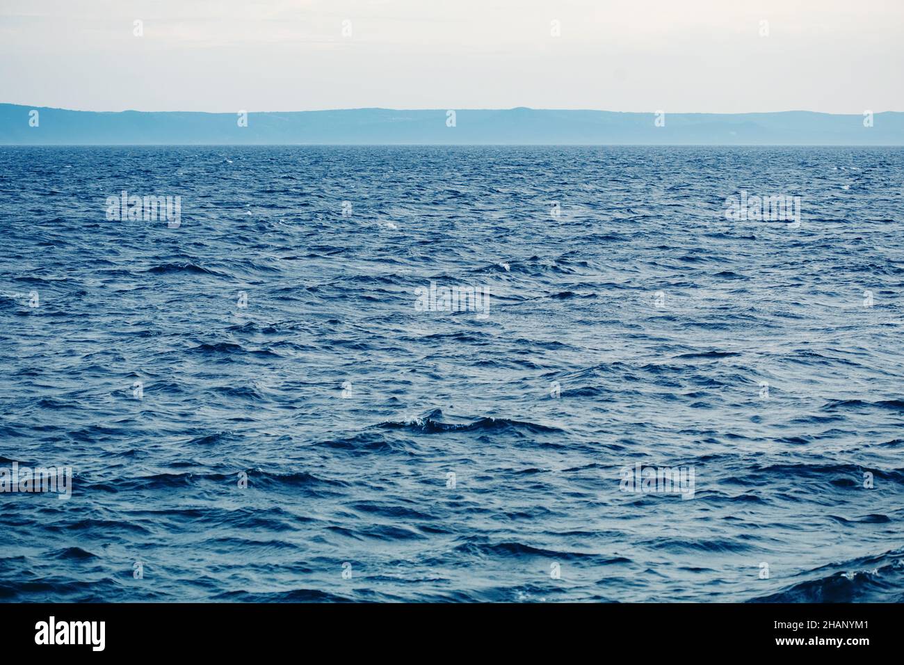 Serene nautical landscape with blue sea water waves, mountains on ...