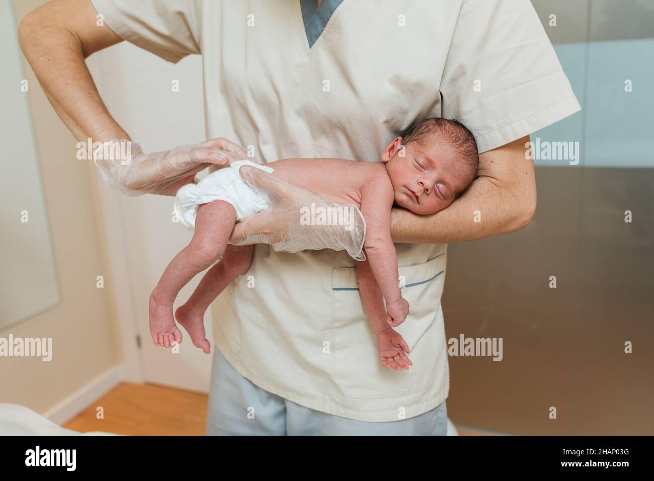 Professional physiotherapist performing an induction of sacral mobility ...