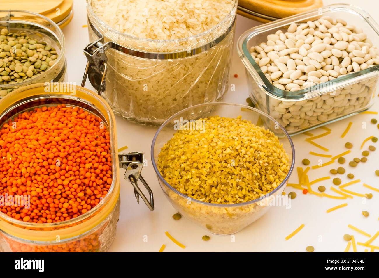Uncooked dry cereal food group in glass containers on white surface ...