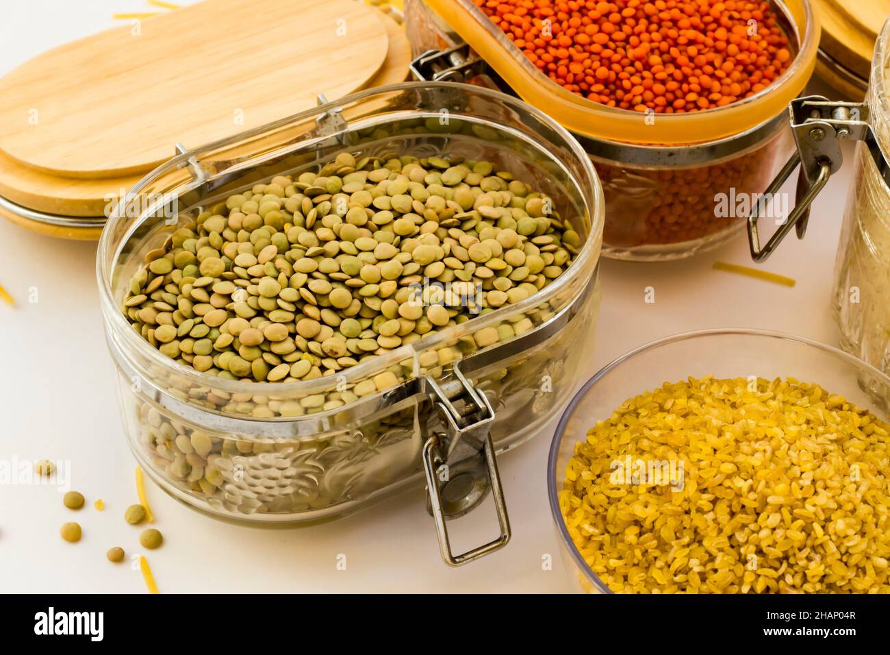 Uncooked dry cereal food group in glass containers on white surface ...