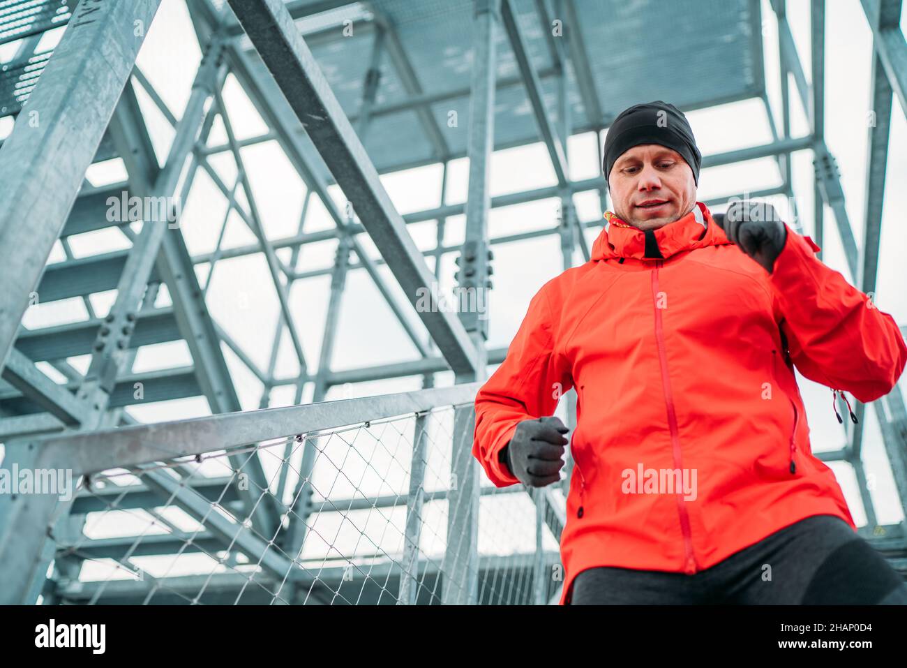 Waist portrait of smiling runner man dressed bright red softshell ...