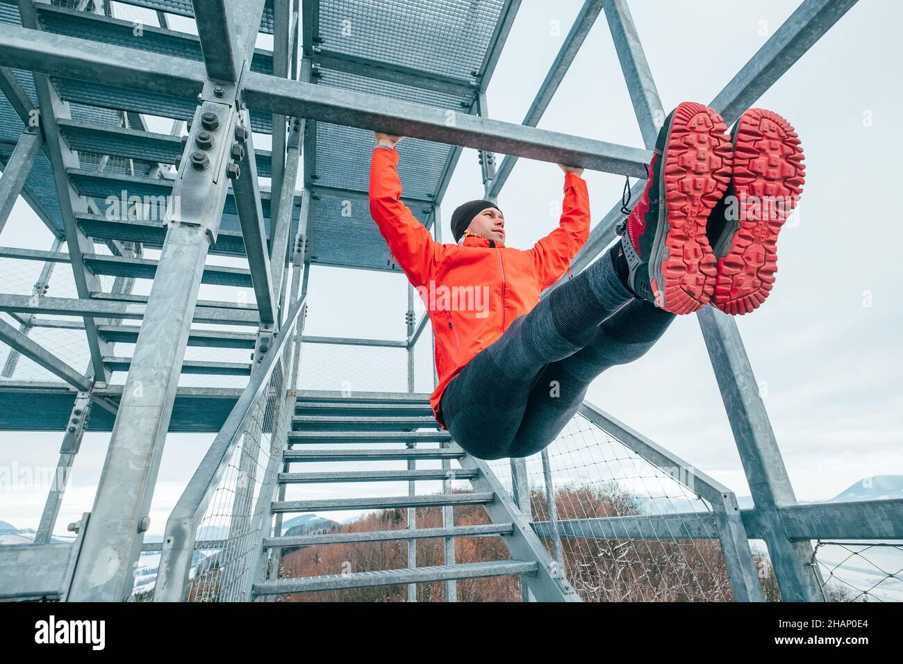 A fit man dressed in bright red sporty clothes and running shoes ...