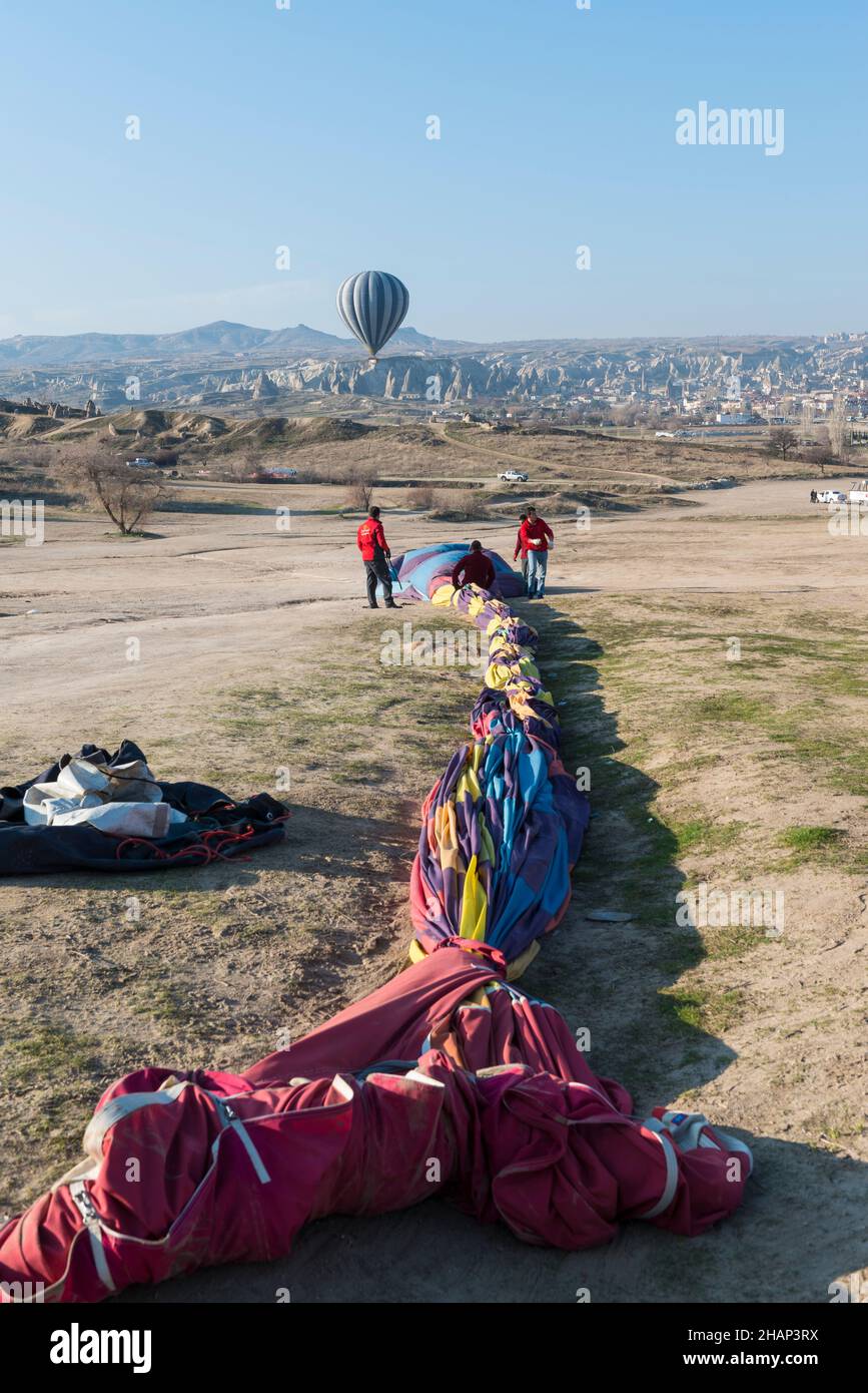 Ground crew members folding a hot air balloon after landing. Cappadocia ...