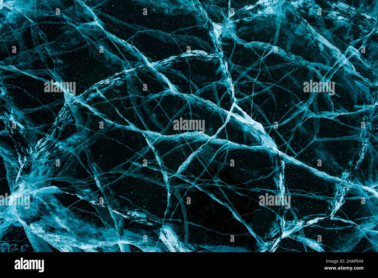 Texture of beautiful dark blue ice with cracks in the frozen lake ...