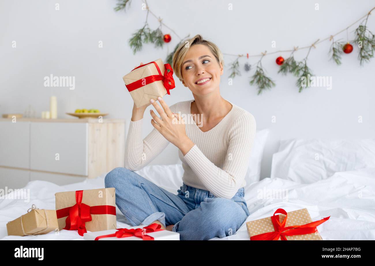 Woman shaking gift box hi-res stock photography and images - Alamy