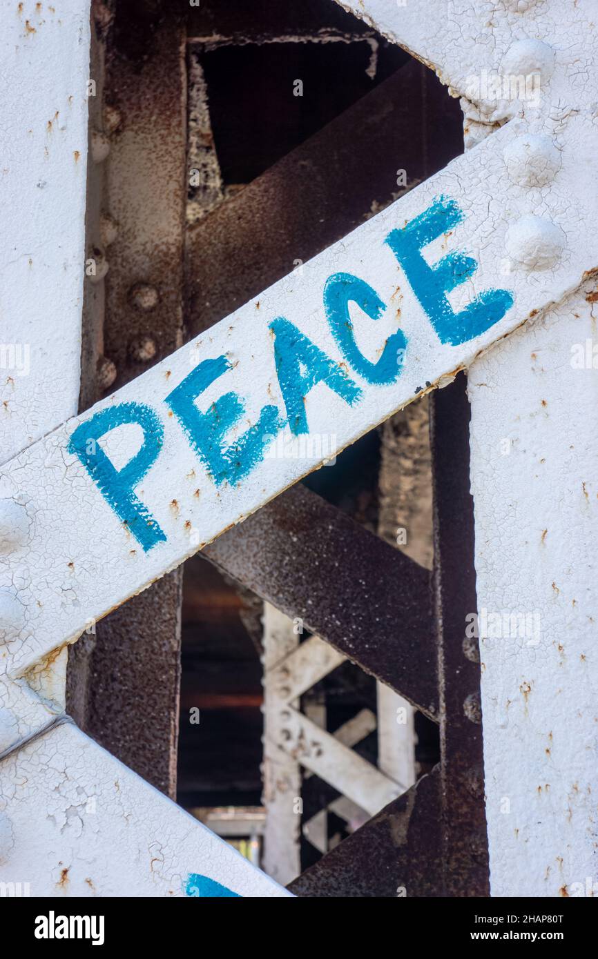 The word peace in blue lettering on a steel section of a viaduct ...