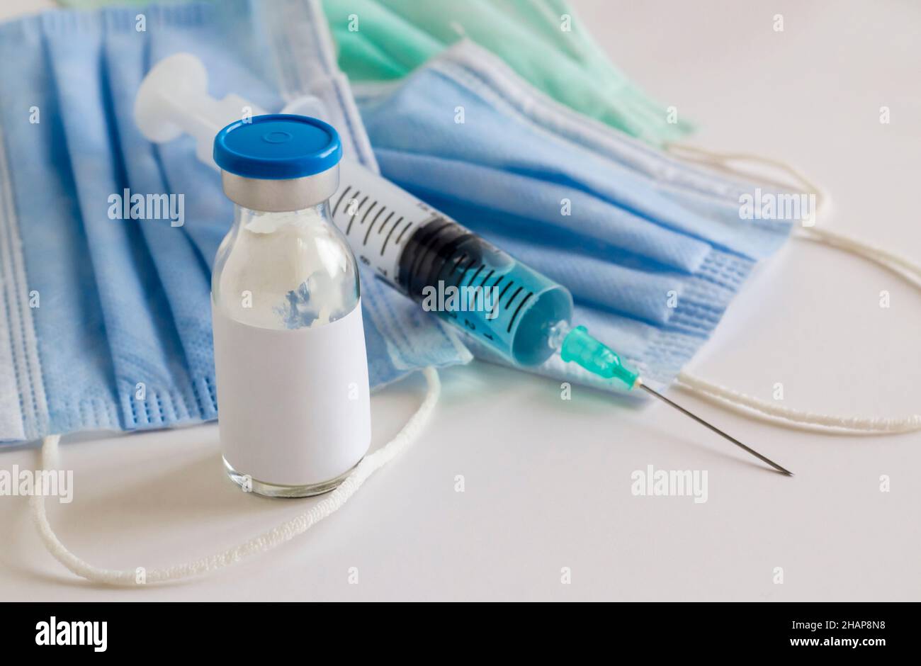 Mini medicine glass bottle and injector with medical masks on white ...