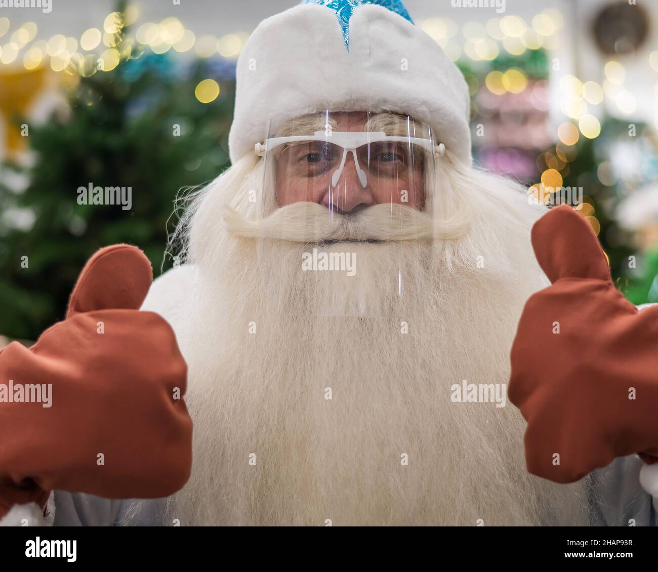 Portrait of Russian santa claus wearing a protective visor shows thumbs ...