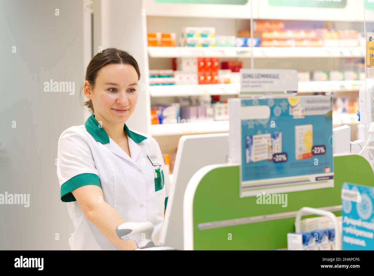 Diligent positive female pharmacist counseling customer in pharmacy ...
