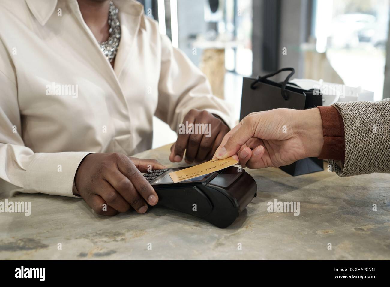 Hand of young male customer paying for purchase while holding plastic ...