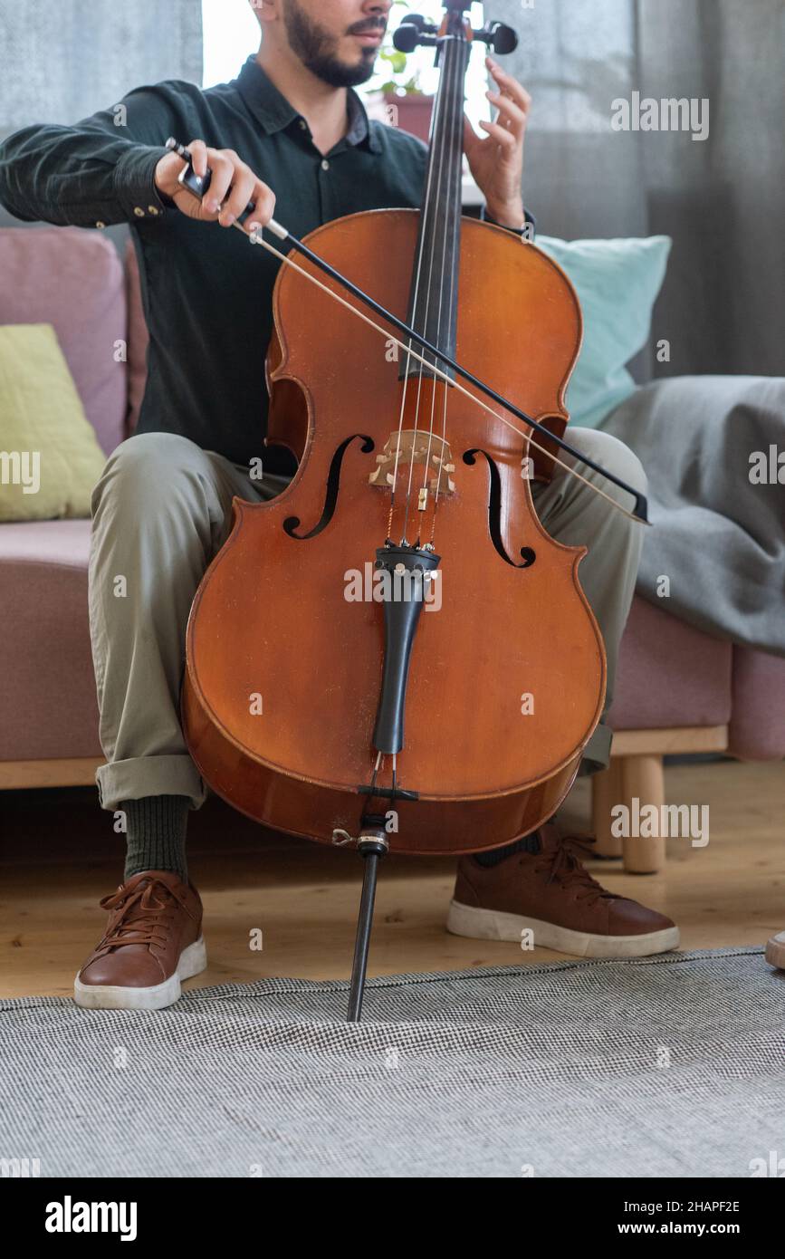 Young man in casualwear sitting on couch in home environment and ...