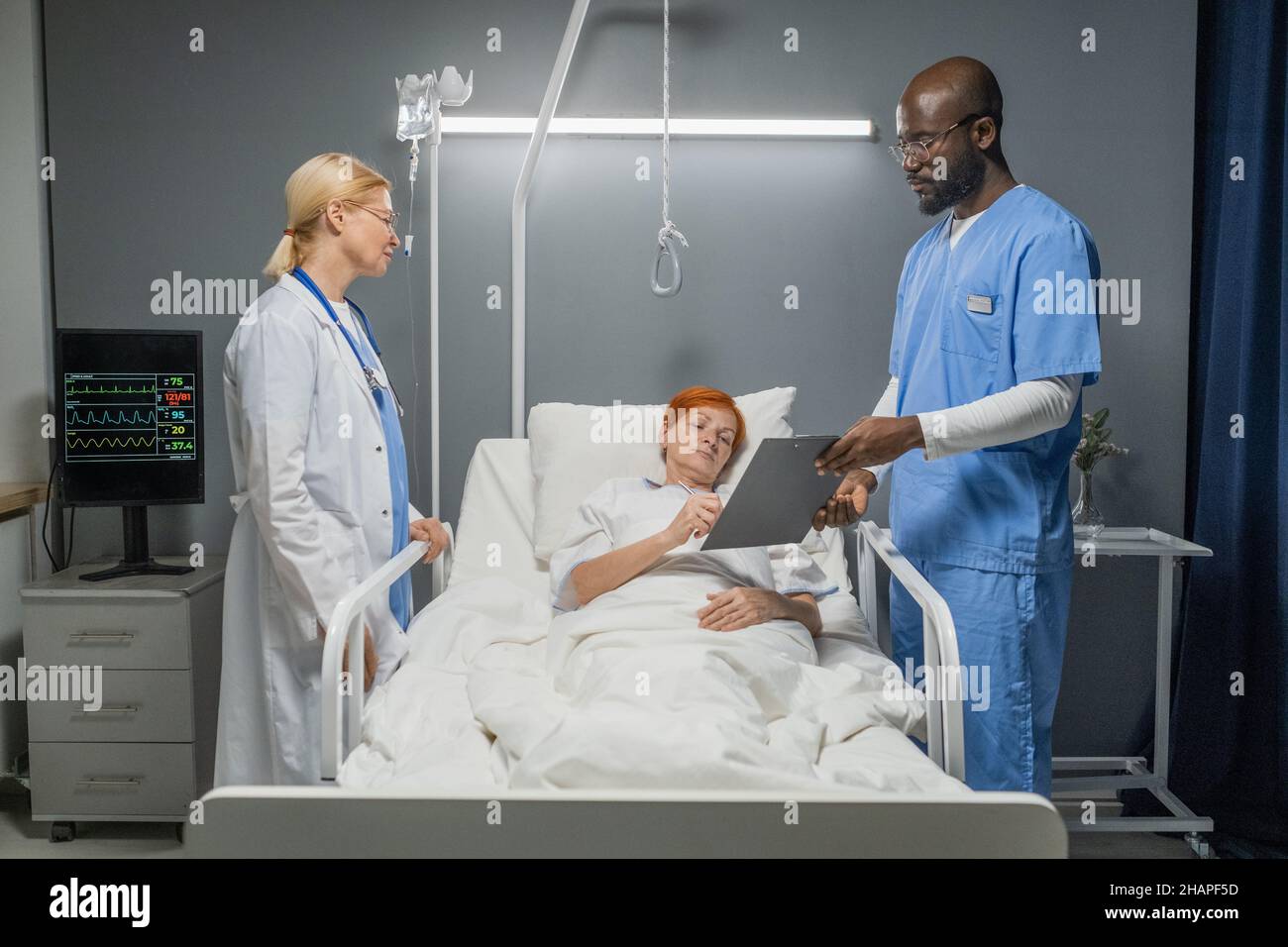 Elderly woman signing an agreement for operation giving by the ...