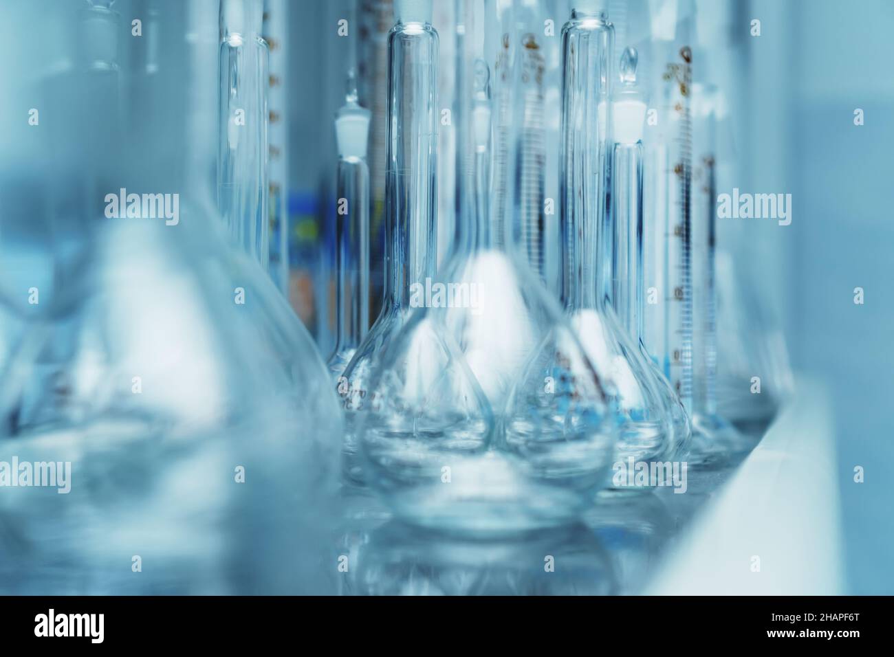 Laboratory flasks in a row on a shelf in the laboratory. Science and ...