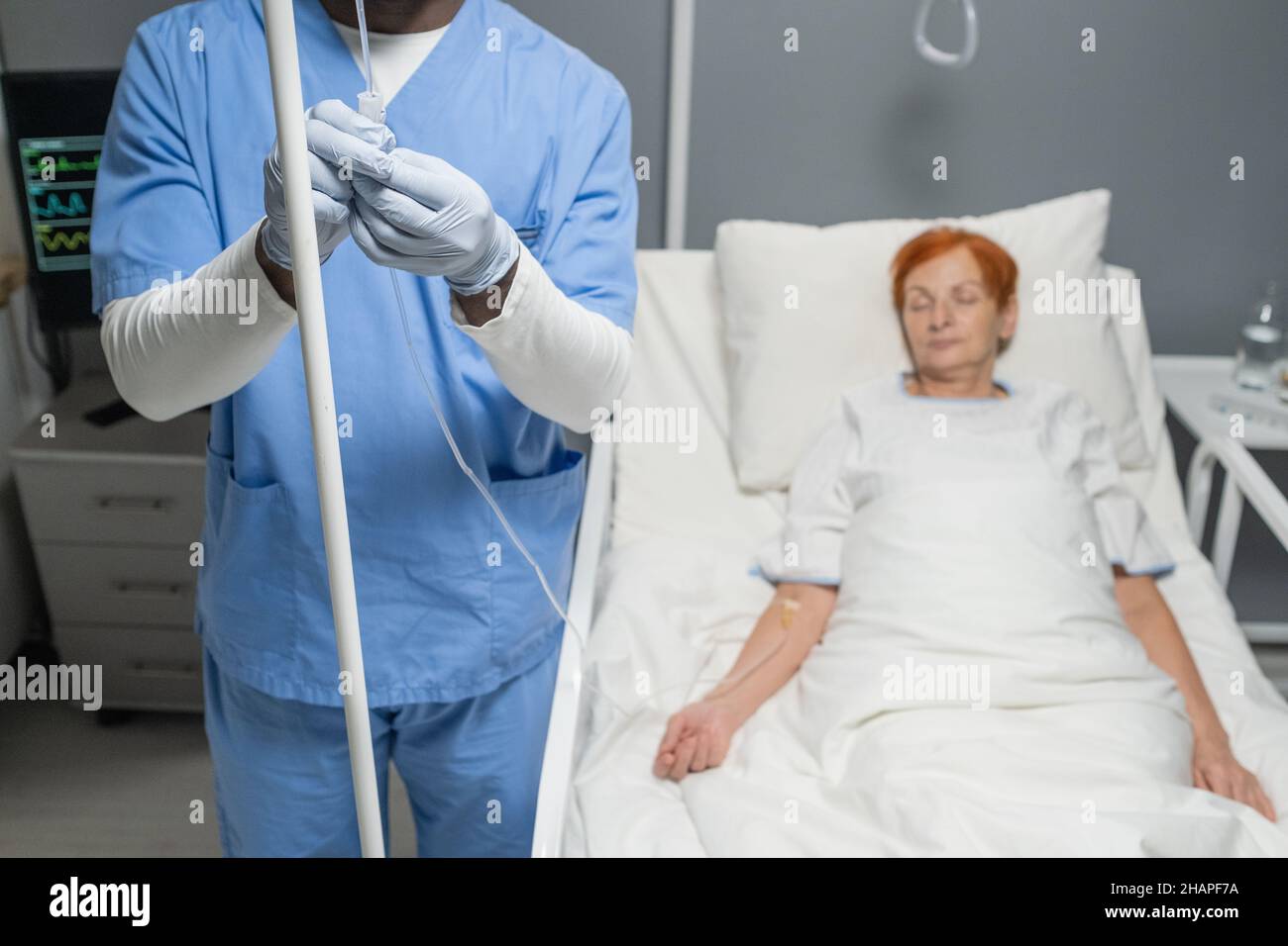 Close-up of African anesthesiologist in uniform making anesthesia for ...