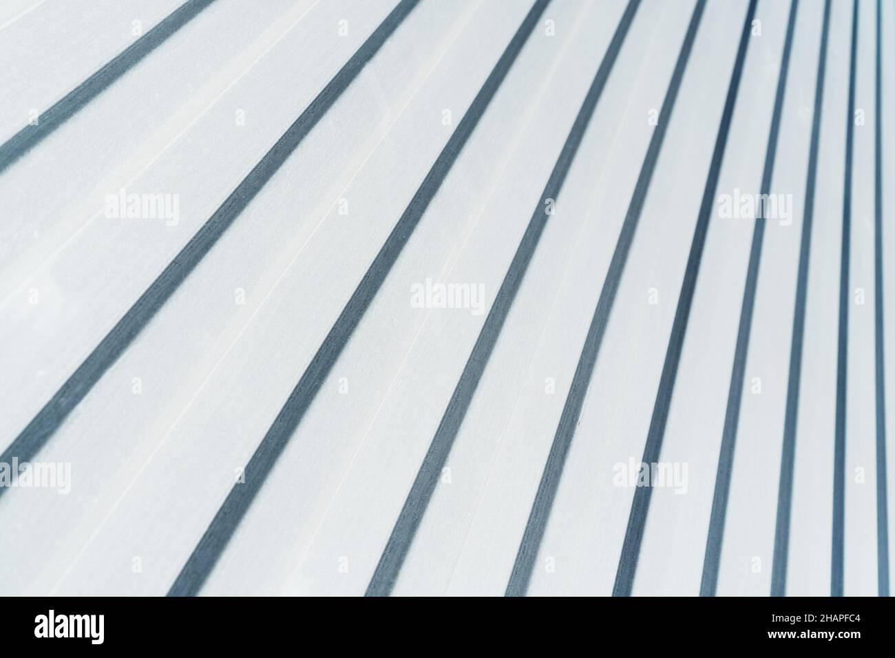 Metal siding with a corrugated pattern of white color diagonally ...