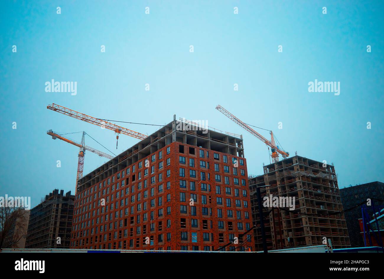 Construction cranes building house premise Stock Photo - Alamy