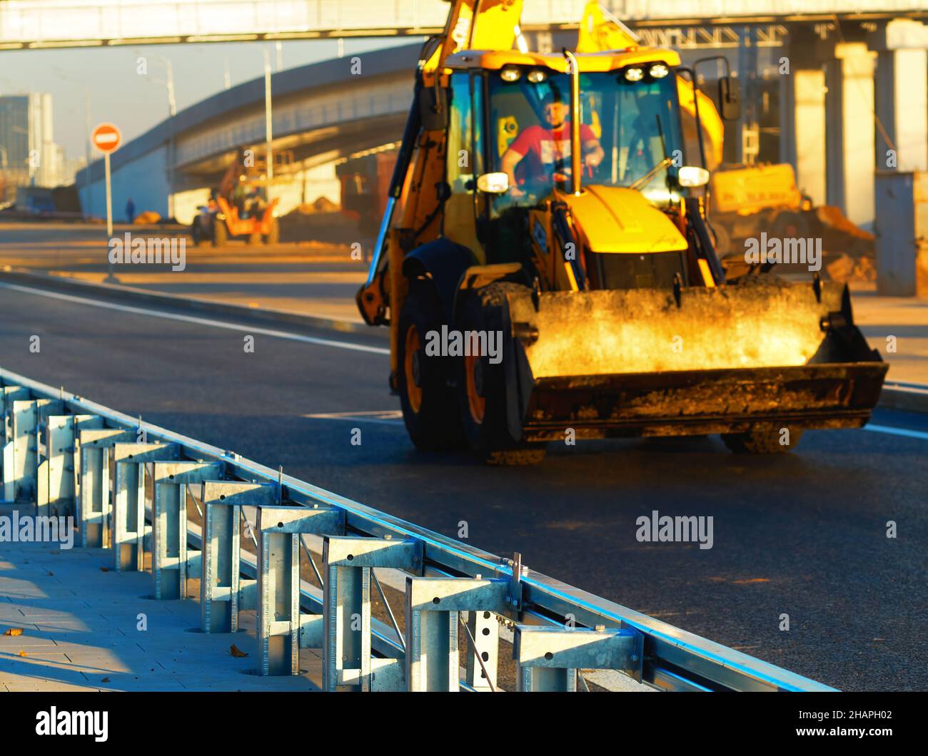 Moving machinery on sunset road background Stock Photo - Alamy