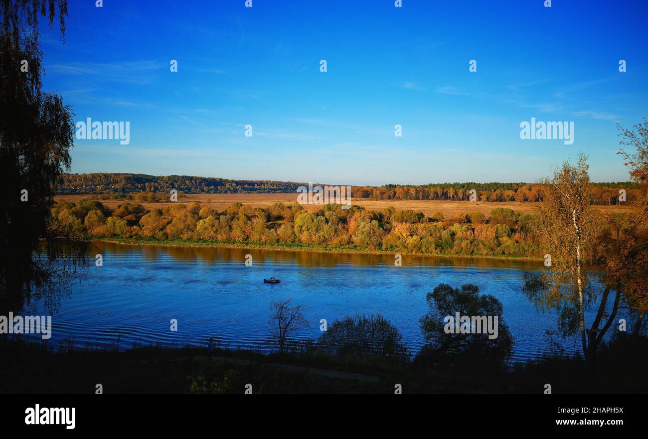 Fishing in boat on autumn river landscape Stock Photo - Alamy