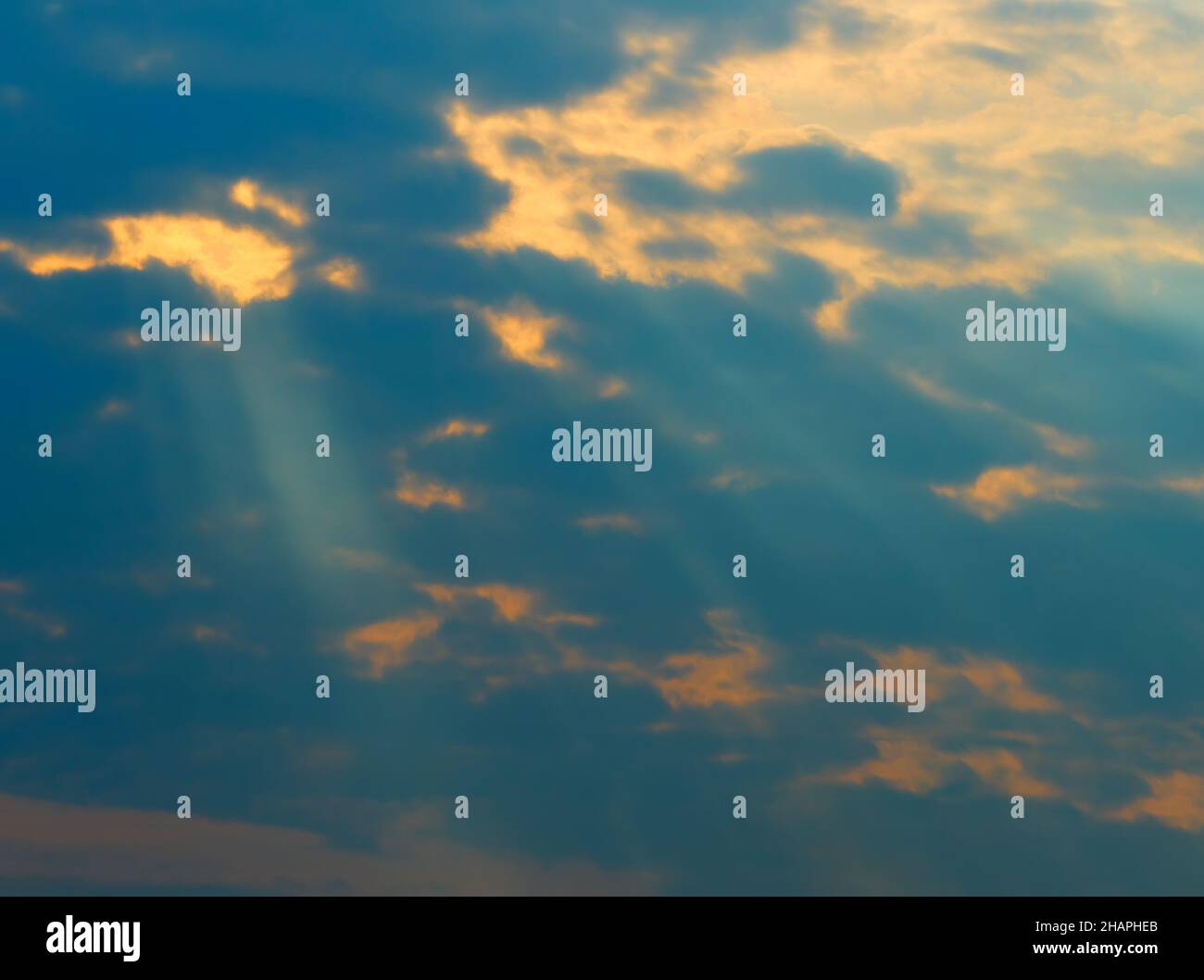 Dramatic light rays coming out of clouds background Stock Photo - Alamy