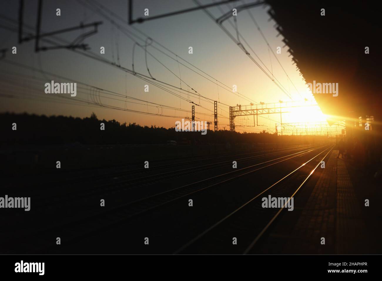 Sunset flare at railway station background Stock Photo - Alamy