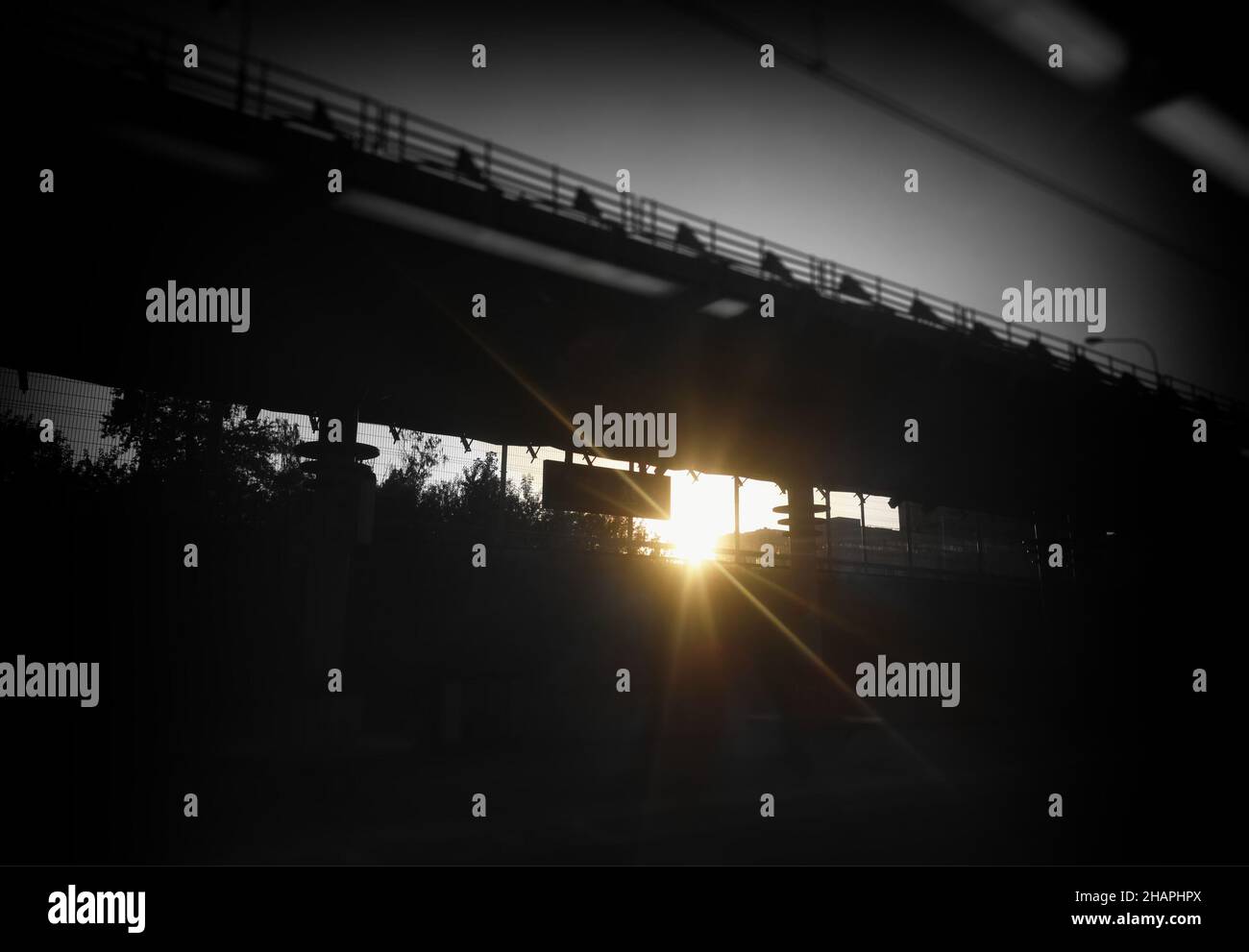 Sunset flare under city bridge background Stock Photo - Alamy