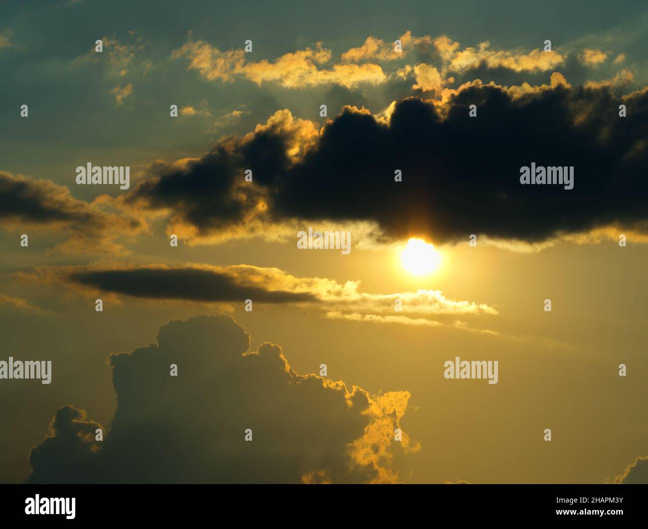 Sun covered with big clouds background Stock Photo - Alamy