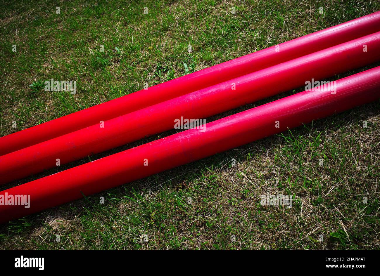 Diagonal pipes on the green grass background Stock Photo - Alamy