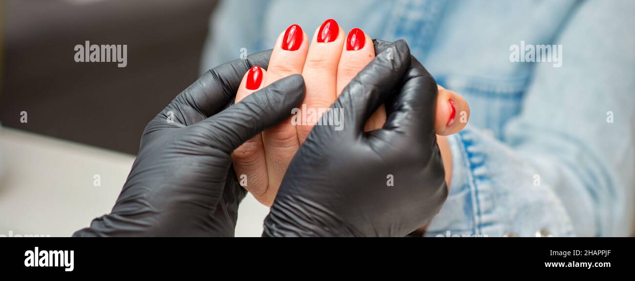 Examination of manicured fingernails. Hands of manicure master in black ...