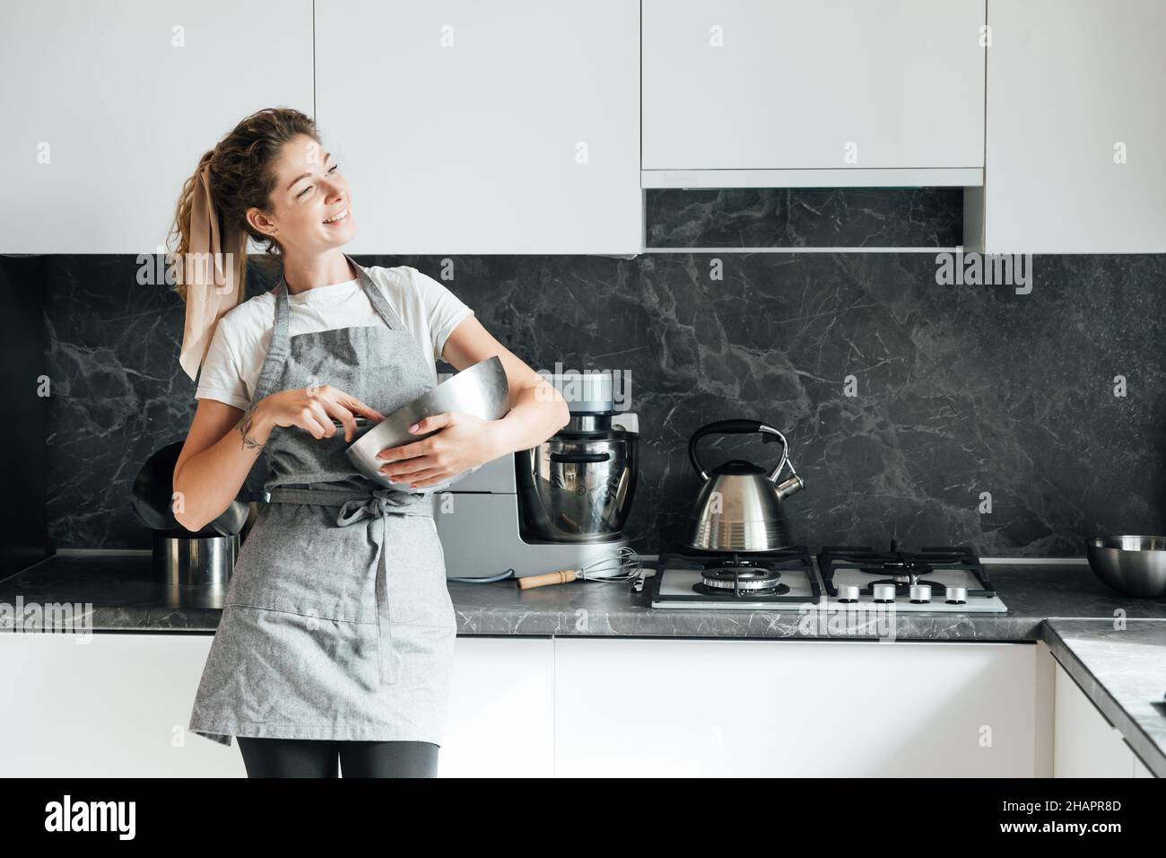 beautiful woman housewife cooks food in the kitchen Stock Photo - Alamy