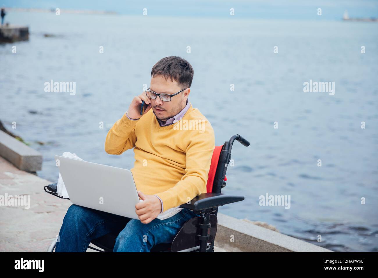 a man with disabilities in a wheelchair talking on a smartphone Stock ...