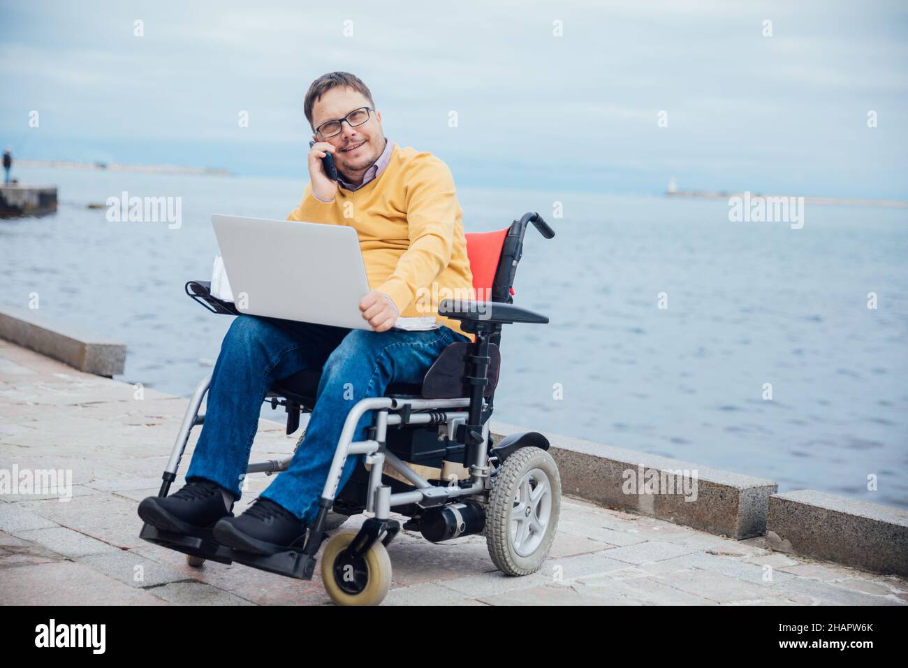 a man with disabilities in a wheelchair talking on a smartphone Stock ...