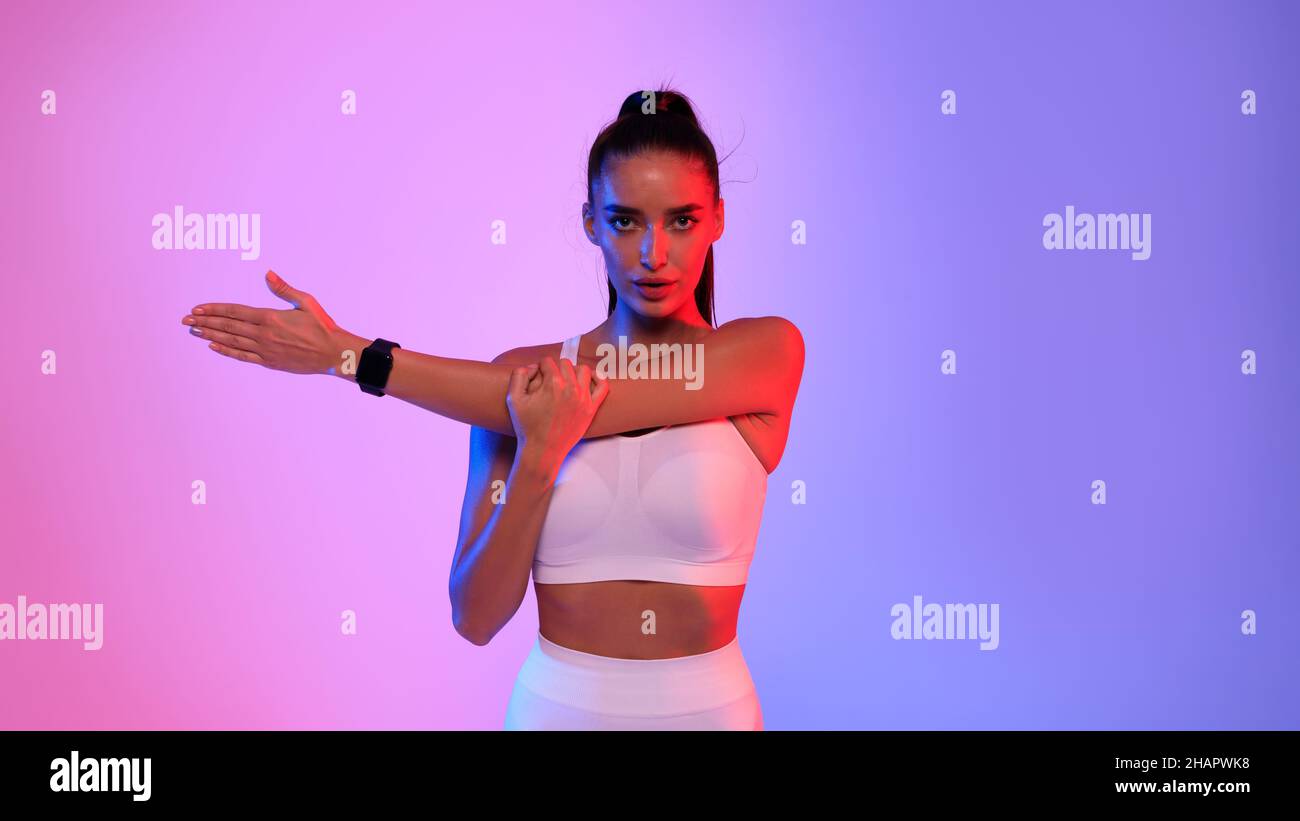 Fit Lady Stretching Arms Wearing Fitness Watch Exercising, Studio Shot ...