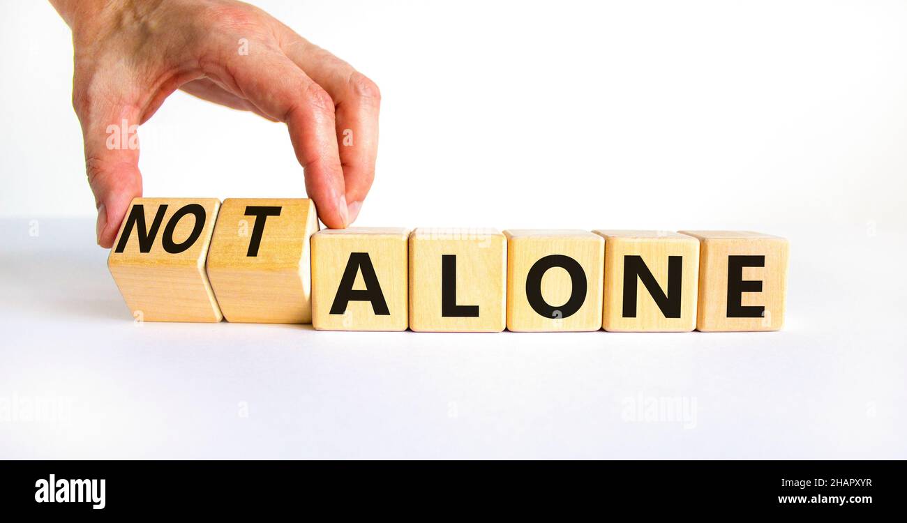 You are not alone symbol. Businessman turns wooden cubes and changes ...