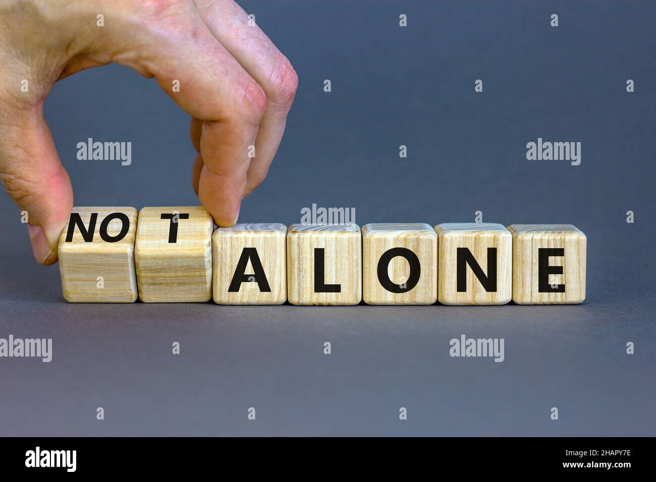 You are not alone symbol. Businessman turns wooden cubes and changes ...