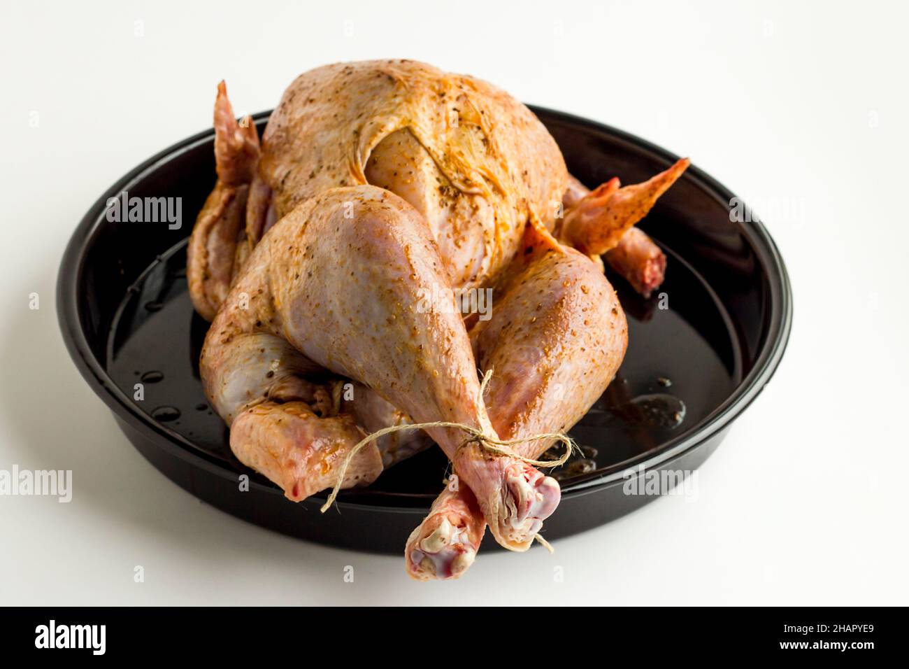 Marinated big size turkey,ready for cook in black, round oven container ...