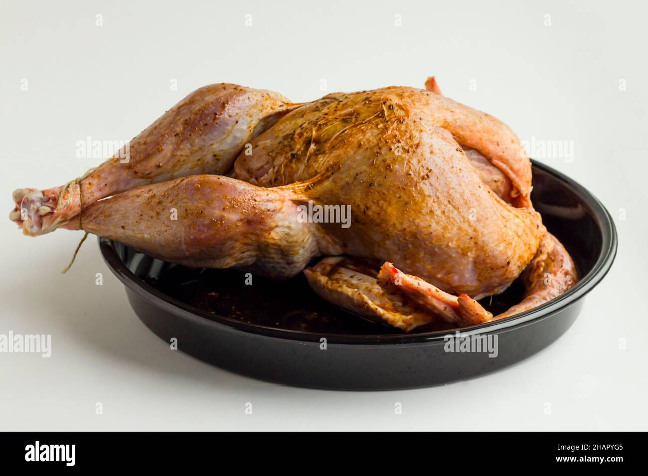 Marinated big size turkey,ready for cook in black, round oven container ...