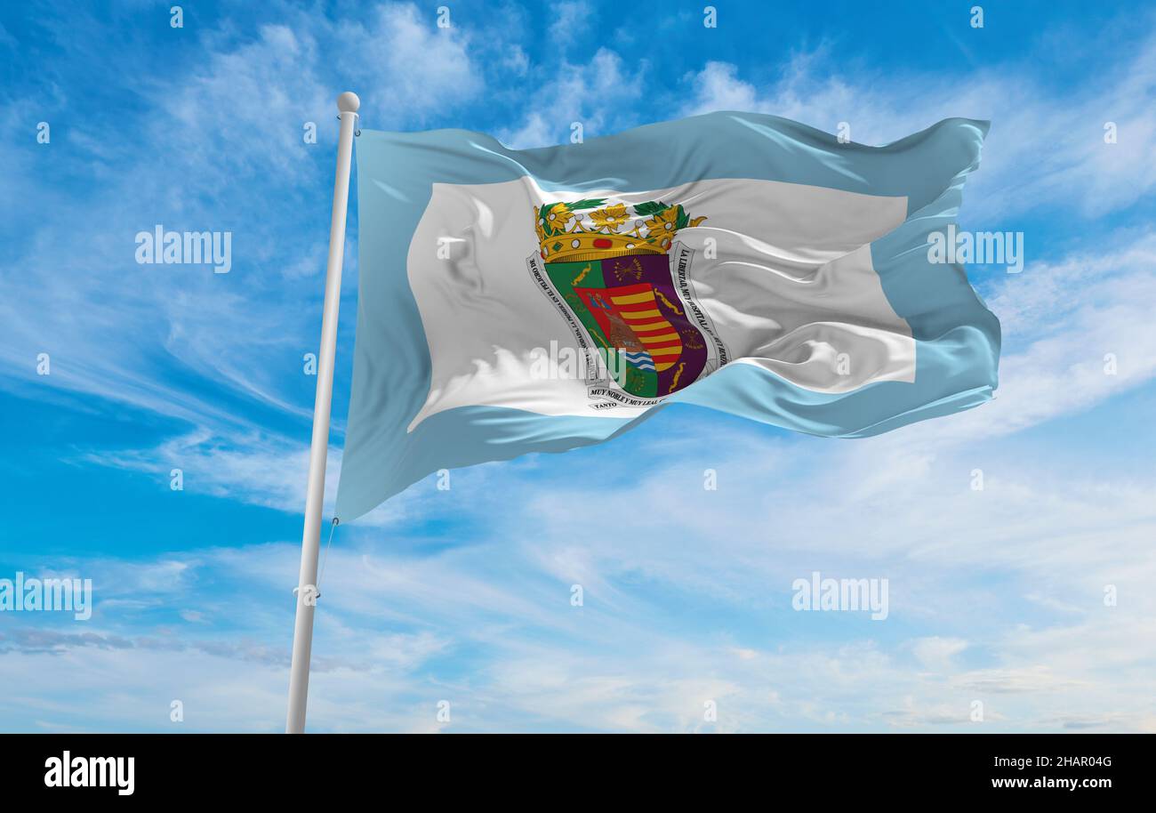 flag of Malaga Province , Spain at cloudy sky background on sunset ...