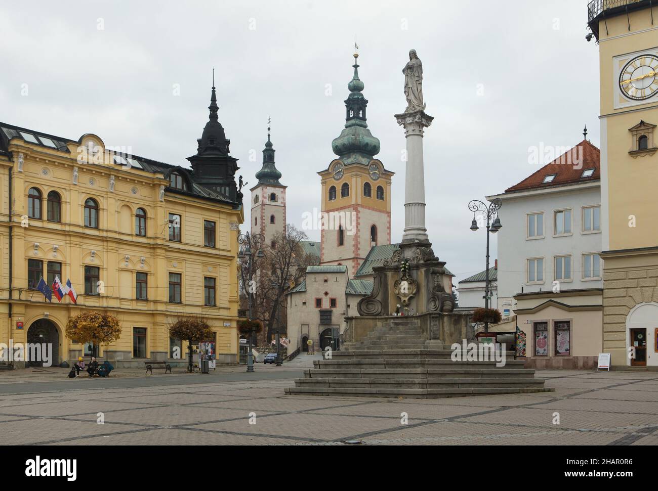 Plague Column in the SNP Square in Banská Bystrica, Slovakia. The medieval barbican with the ...