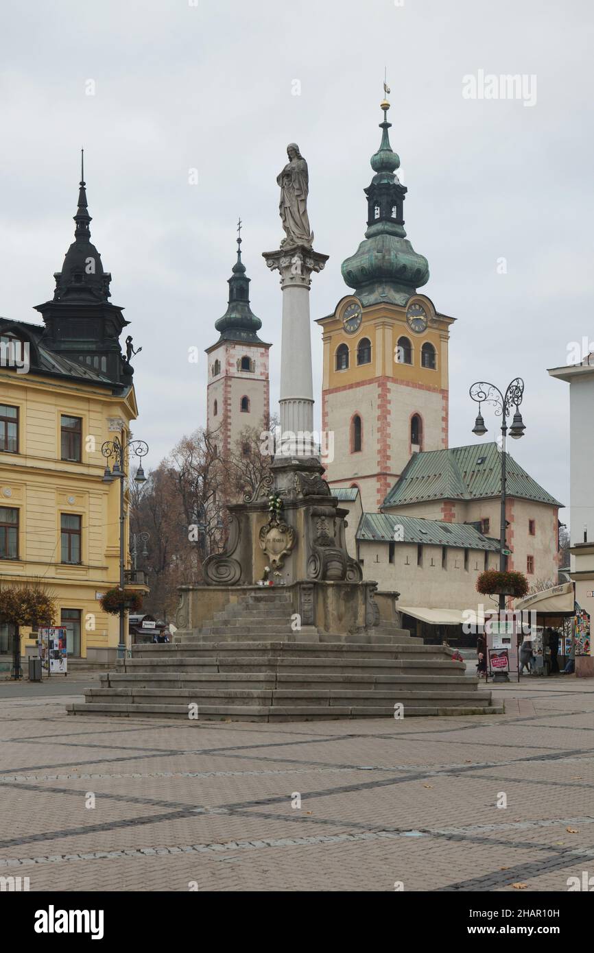 Plague Column in the SNP Square in Banská Bystrica, Slovakia. The medieval barbican with the ...