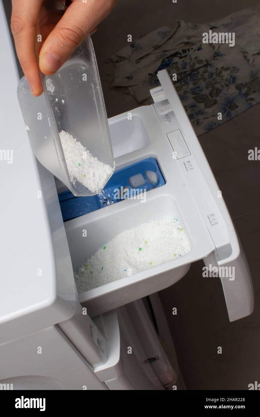 Close up of female hand pouring washing powder detergent into washing ...