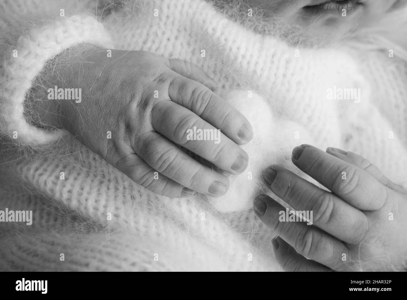 Soft hands of new born hold woolen heart. Fingers of newborn baby hands ...