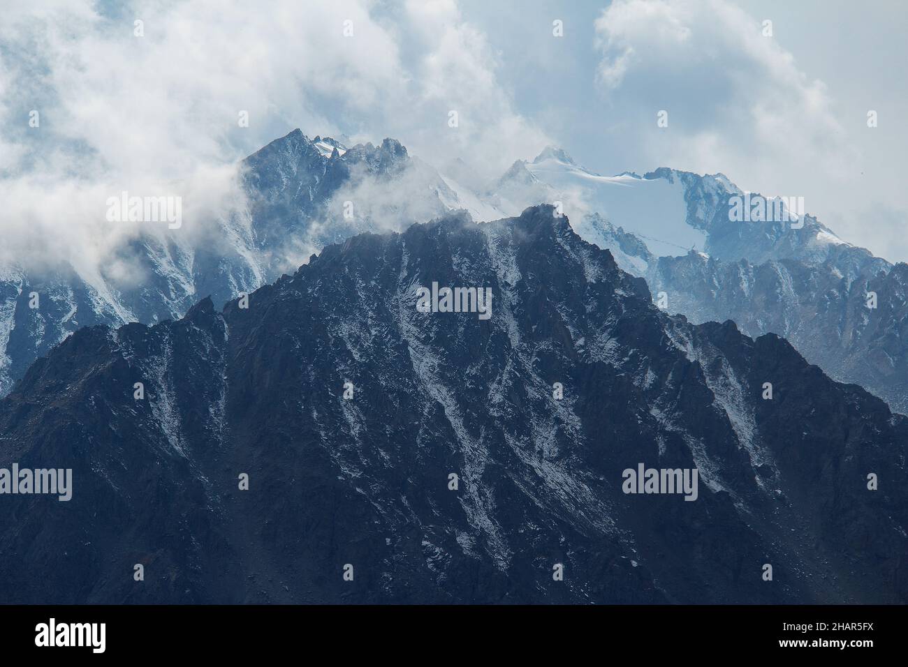 Mountain snowy peaks with clouds on a sunny day Stock Photo - Alamy